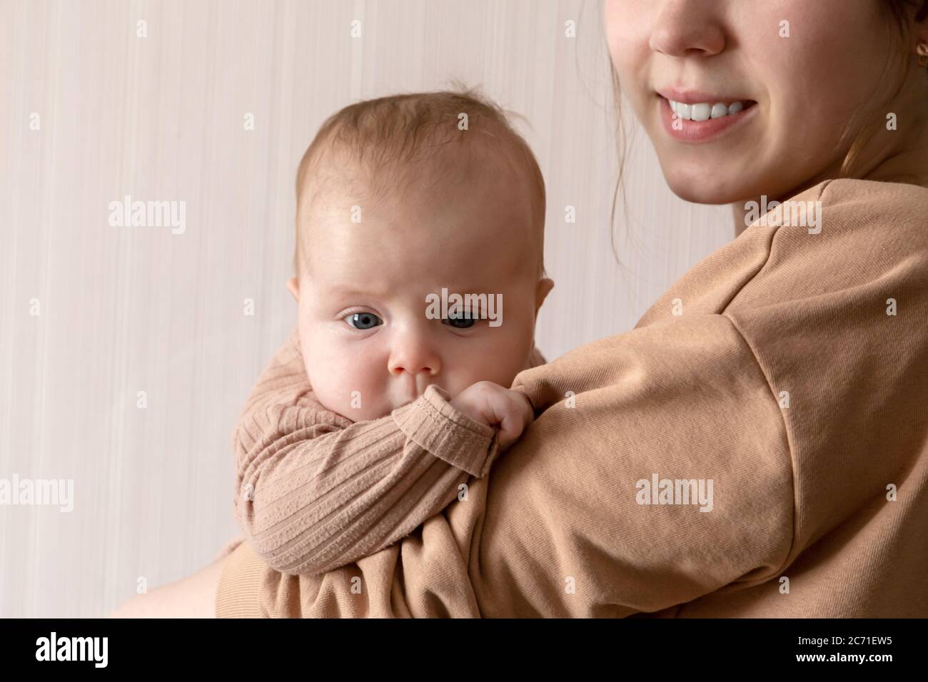 A young mother holds a child girl who is 3 months old. The brooding ...