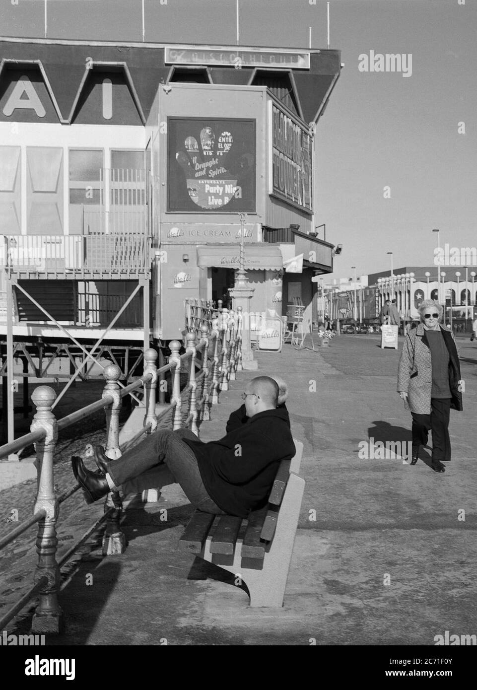 People sitting on a bench on Blackpool Sea Front, north west England ...