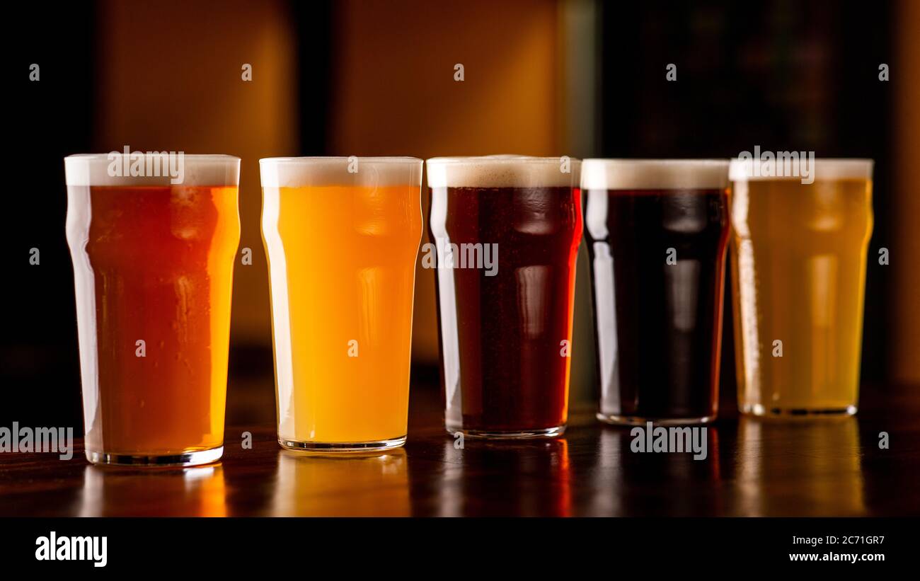 Beer mix in pub. Dark, light, barley, lager and ale in glasses on brown ...