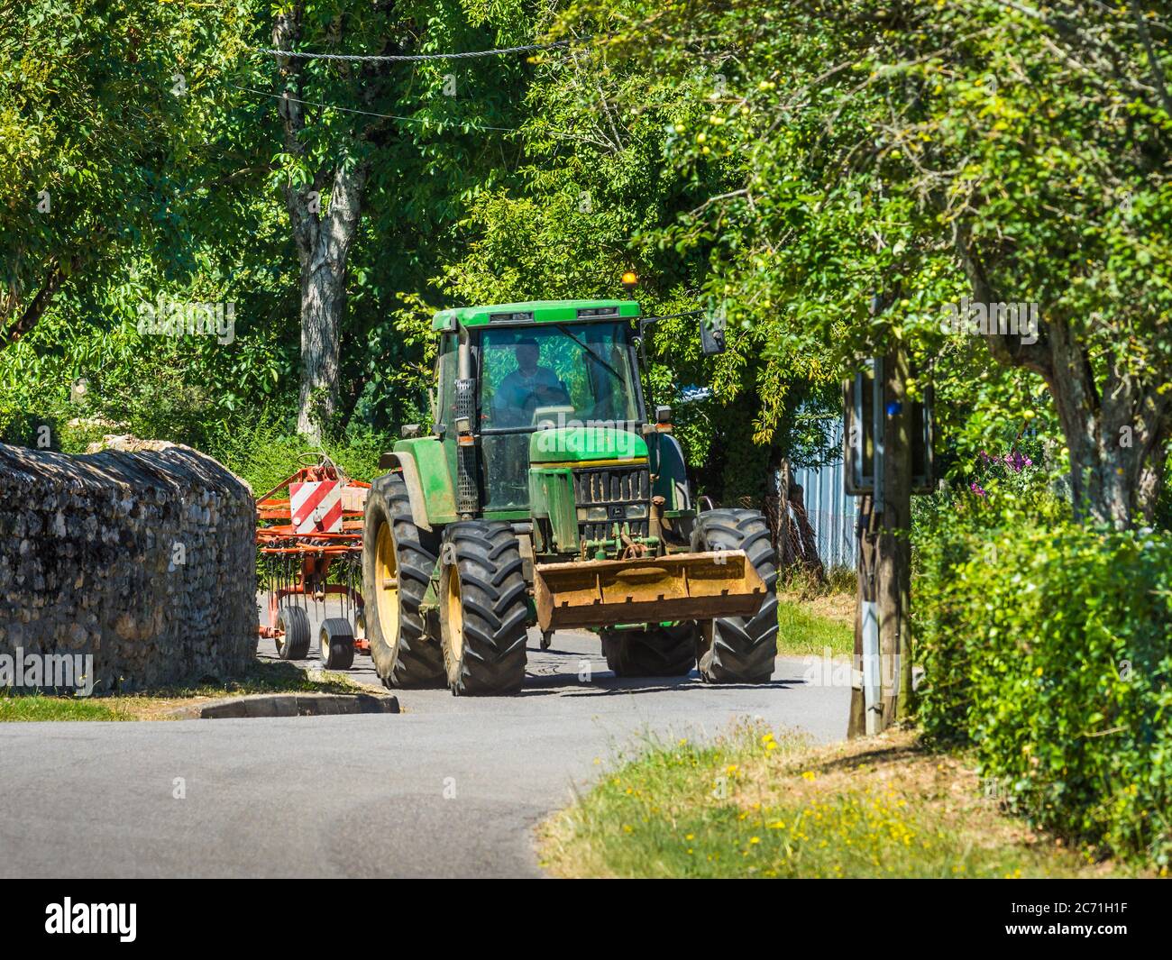 John Deere 7800 tractor and Kuhn GA5002 hay turner negotiating winding ...