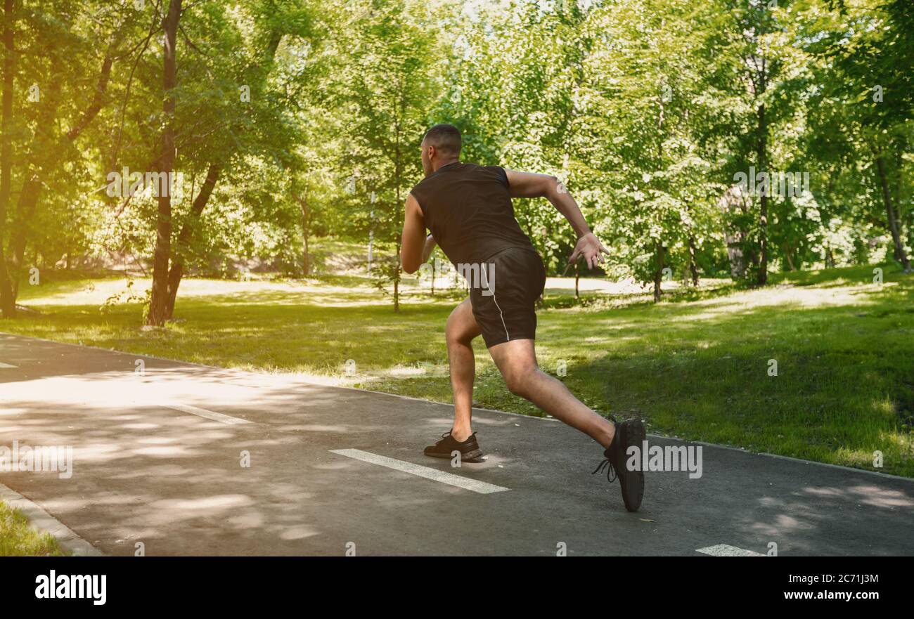 Black sprinter running at park on sunny morning, free space Stock Photo ...