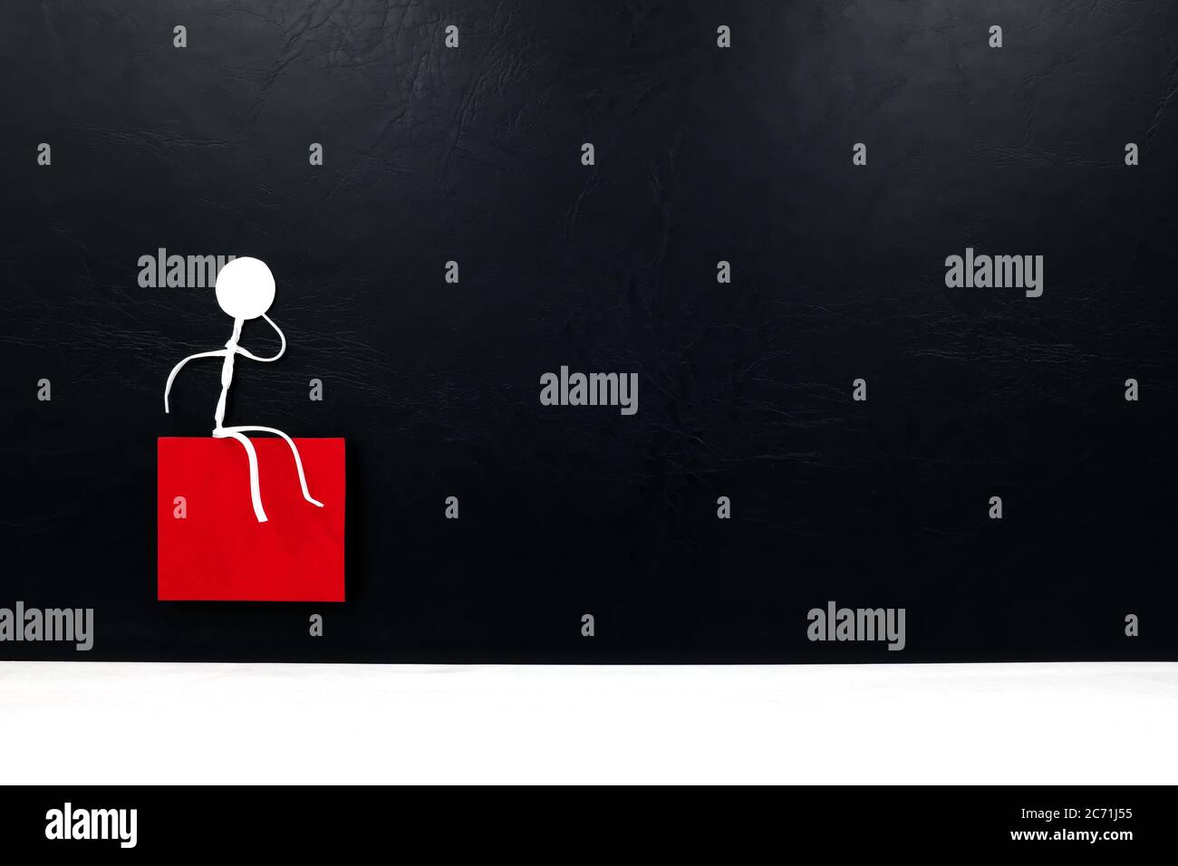 Human stick figure sitting alone in black background with copy space ...