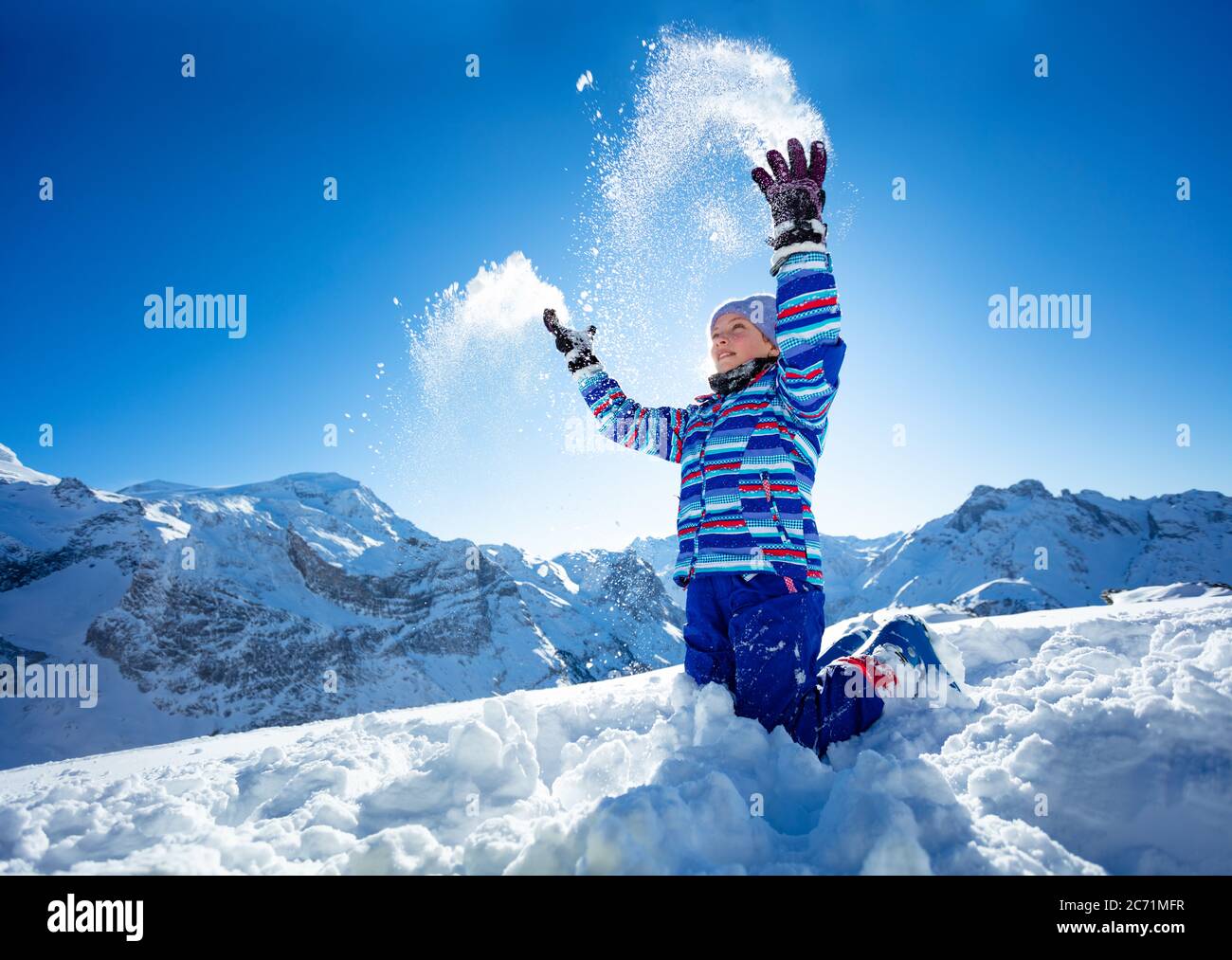 Close action portrait ski girl who throw snow in the air standing on ...