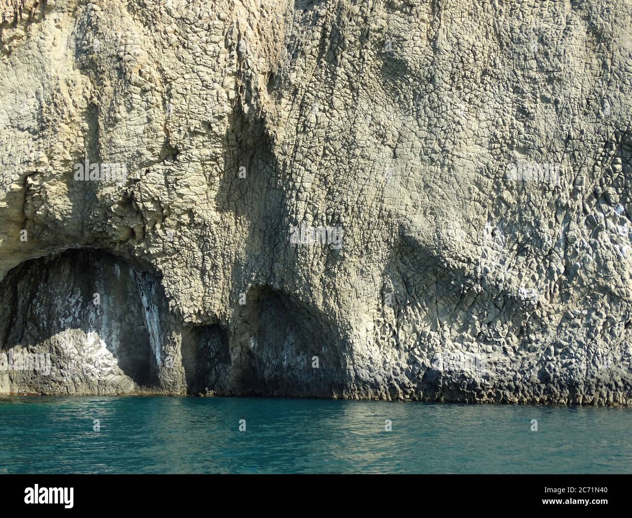 Majestic Rocks rising from the calm sea water Stock Photo - Alamy