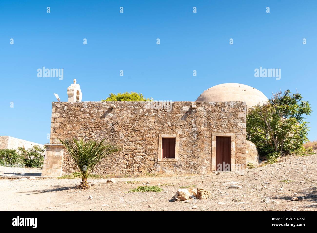Old stone house in the desert with palm tree in front in Crete, Greece ...