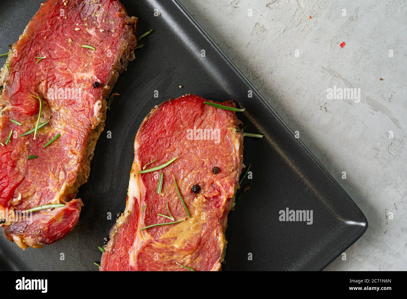 Marinated raw steaks on stone table with spices Stock Photo - Alamy