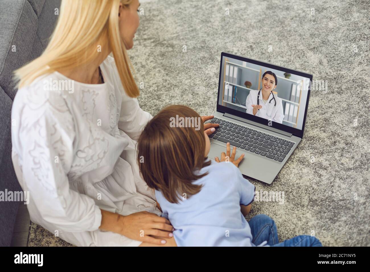Mother with son talking to doctor online from home. Parent and little ...