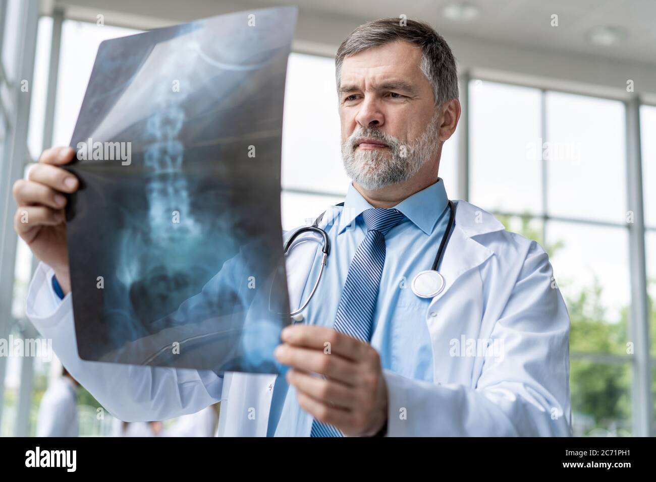 Mature Doctor looking at an x-ray results in a hospital Stock Photo - Alamy
