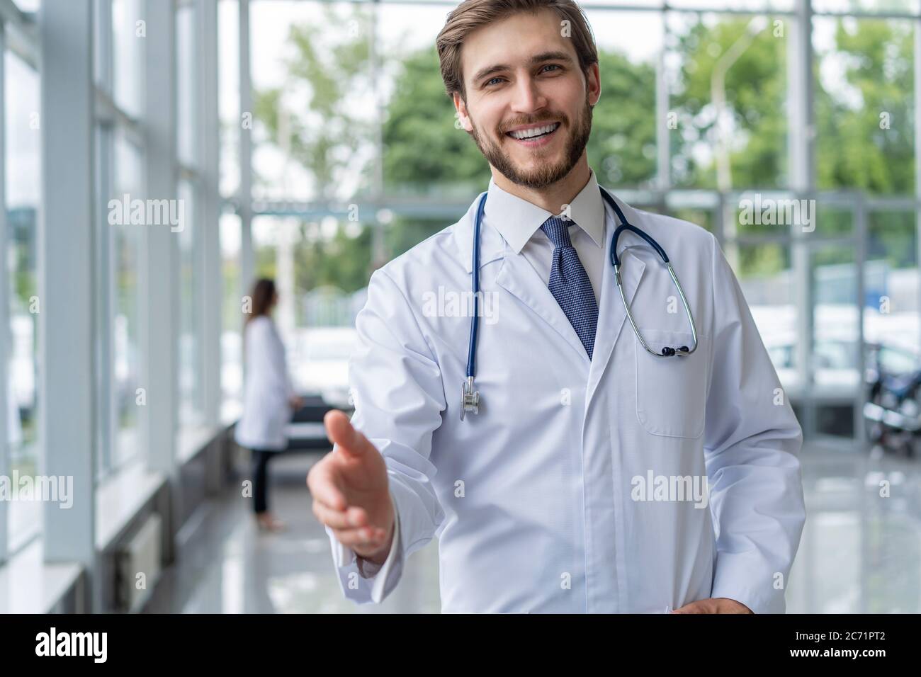 young doctor welcoming at his office. medical doctor man smile, hold ...
