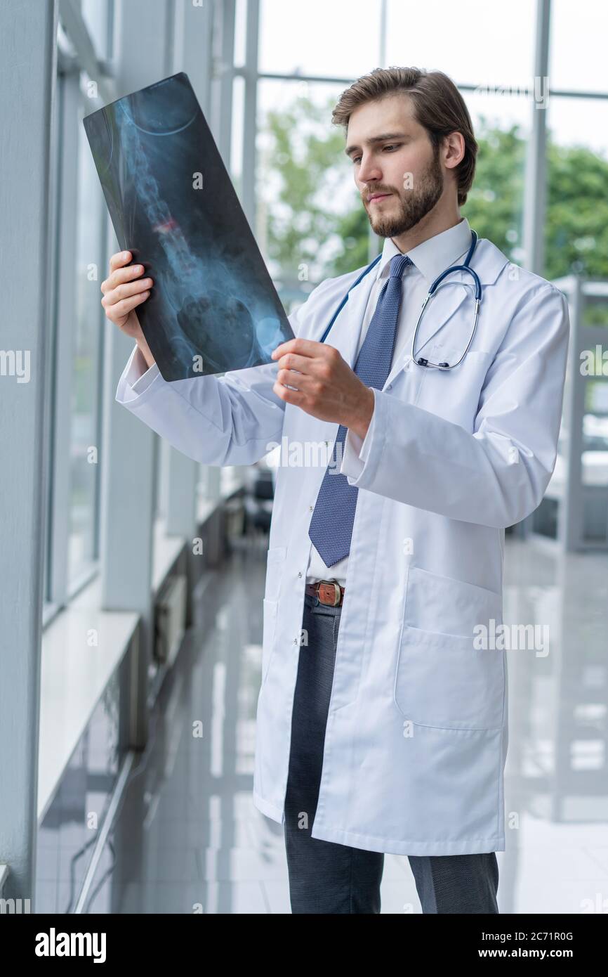 hospital doctor holding patient's x-ray film, radiologist studying x ...