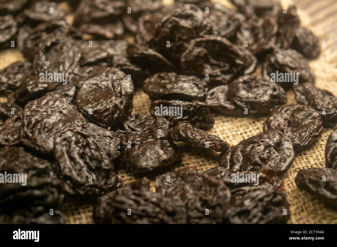 Dried prunes in bulk on burlap with a rough texture. Close up Stock ...
