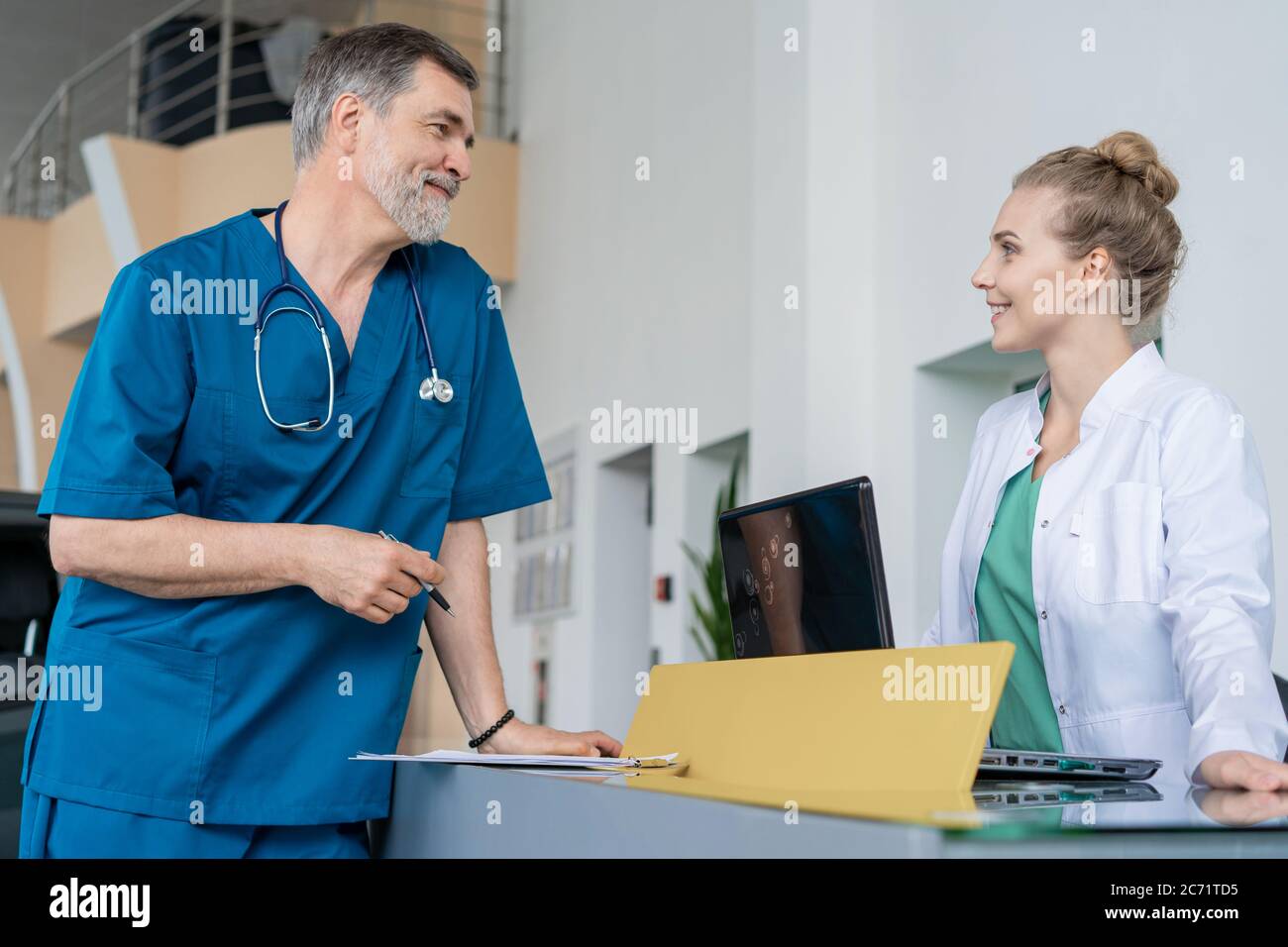 Doctor In Discussion With Nurse At Nurses Station or Hospital Reception ...