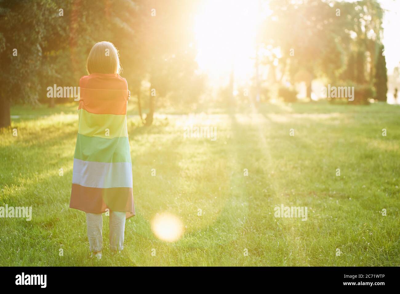 Back view of unrecognizable tolerant woman posing in park, enjoying ...