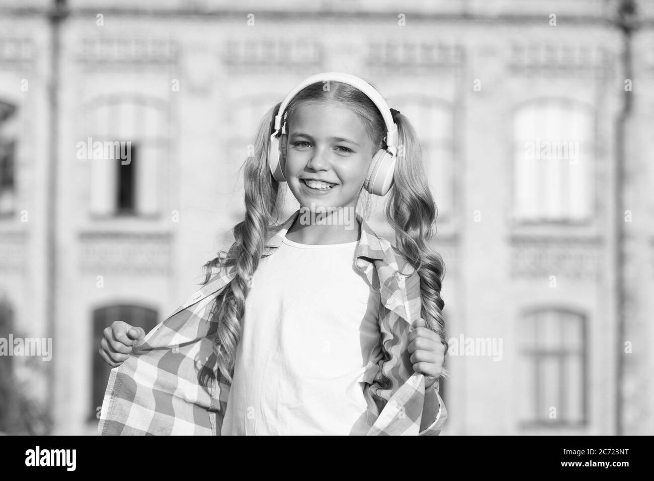 happy school girl wear earphones. little girl casual style outdoor ...