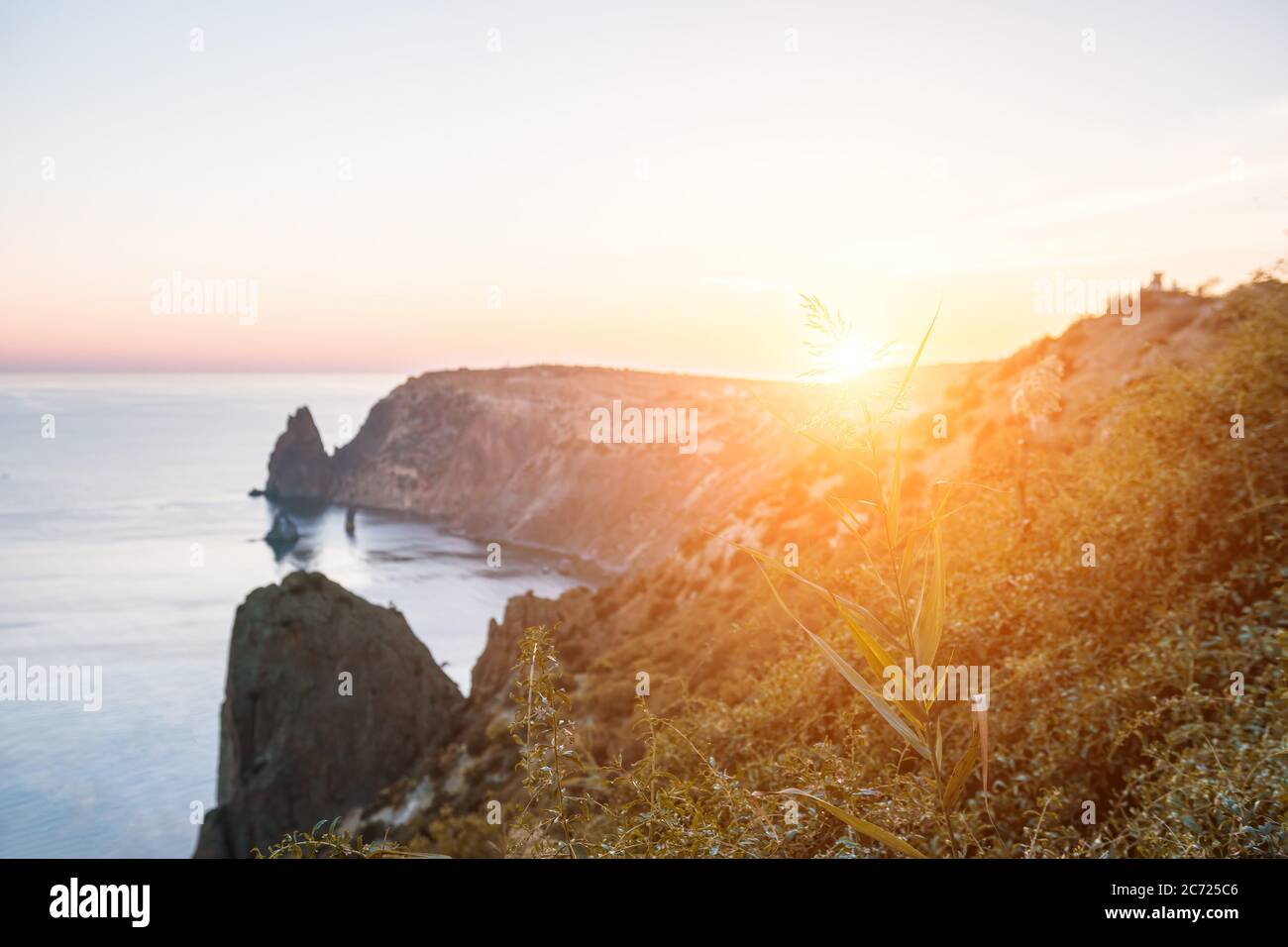 Autumn sea landscape with warm sunset light over rocky coastline. Calm ...