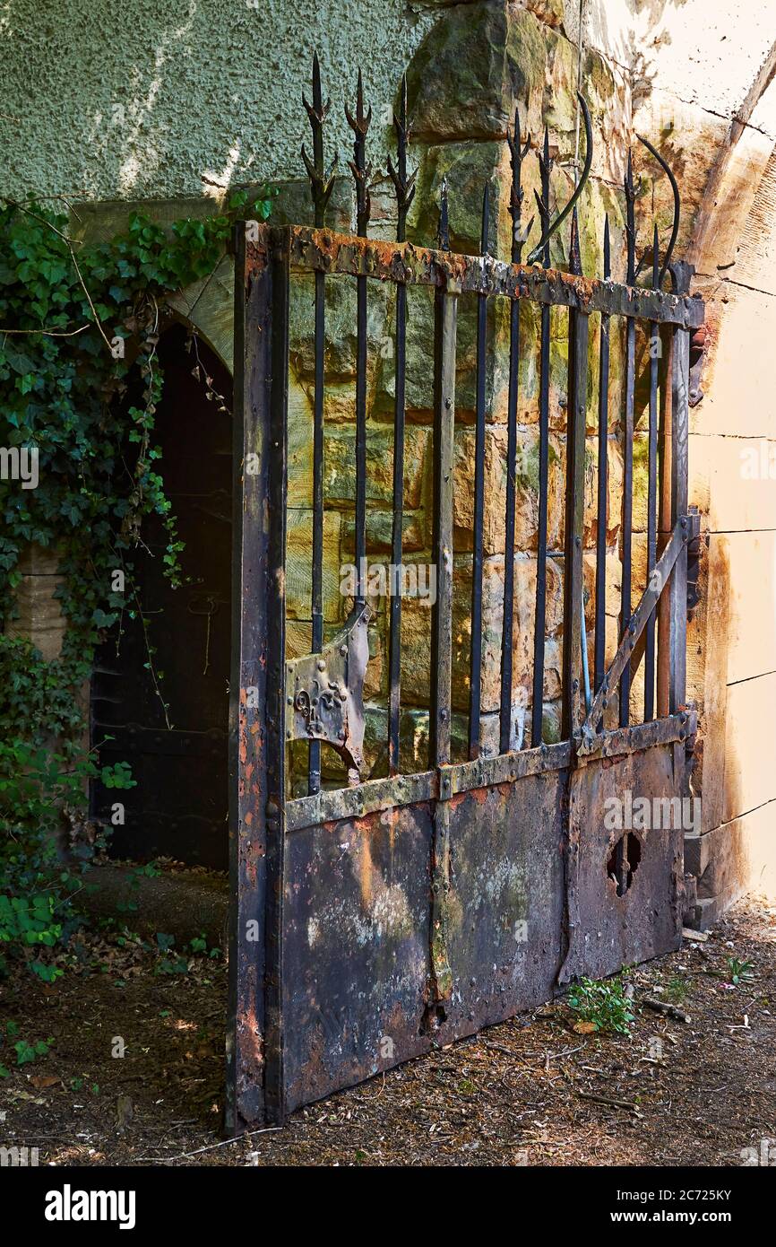 Access to a small old castle. In the center you can see a rusty wrought ...