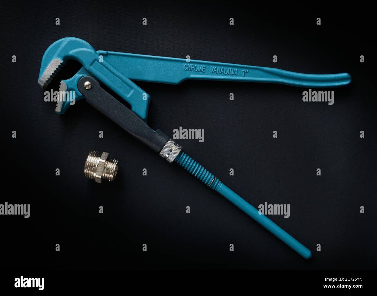 Adjustable wrench and adapter for flexible hoses on dark background ...