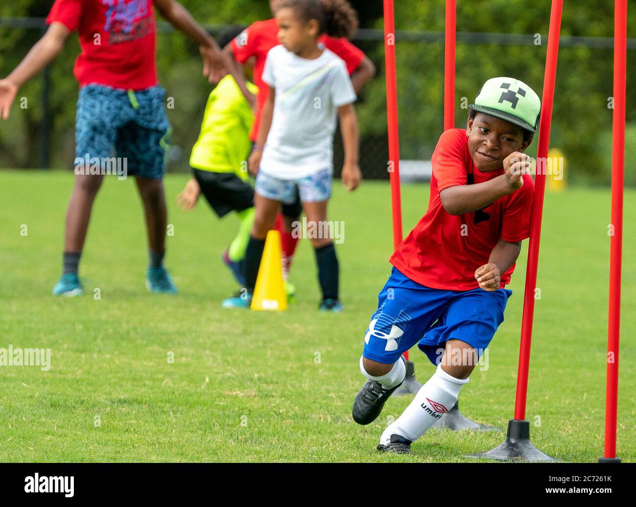 Youngster charges through an obstacle course at summer camp Stock Photo ...