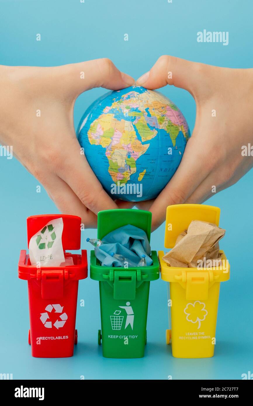 Yellow, green and red recycle bins with recycle symbol on blue ...