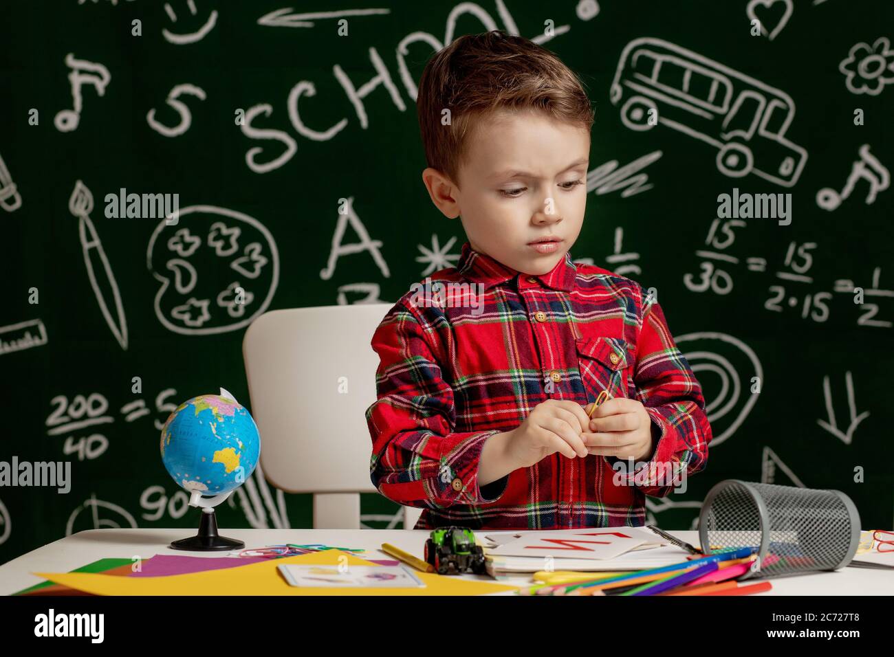 Preschooler boy making school homework. School boy with happy face ...