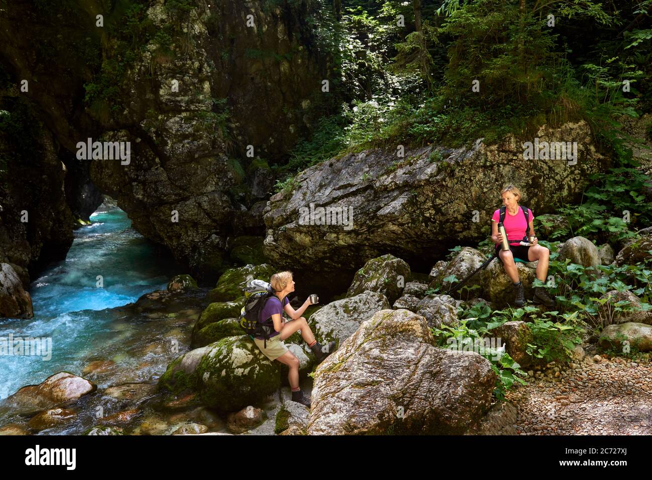 Two women are resting, drinking tea, enjoying the view and talking in a ...