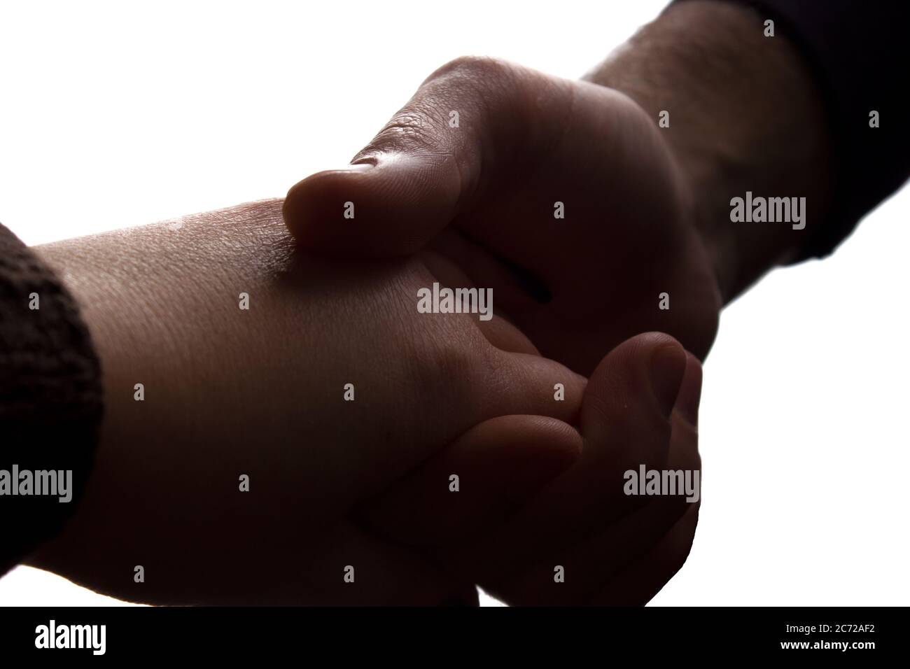 Man gently holding his beloved by the hand - closeup silhouette love ...