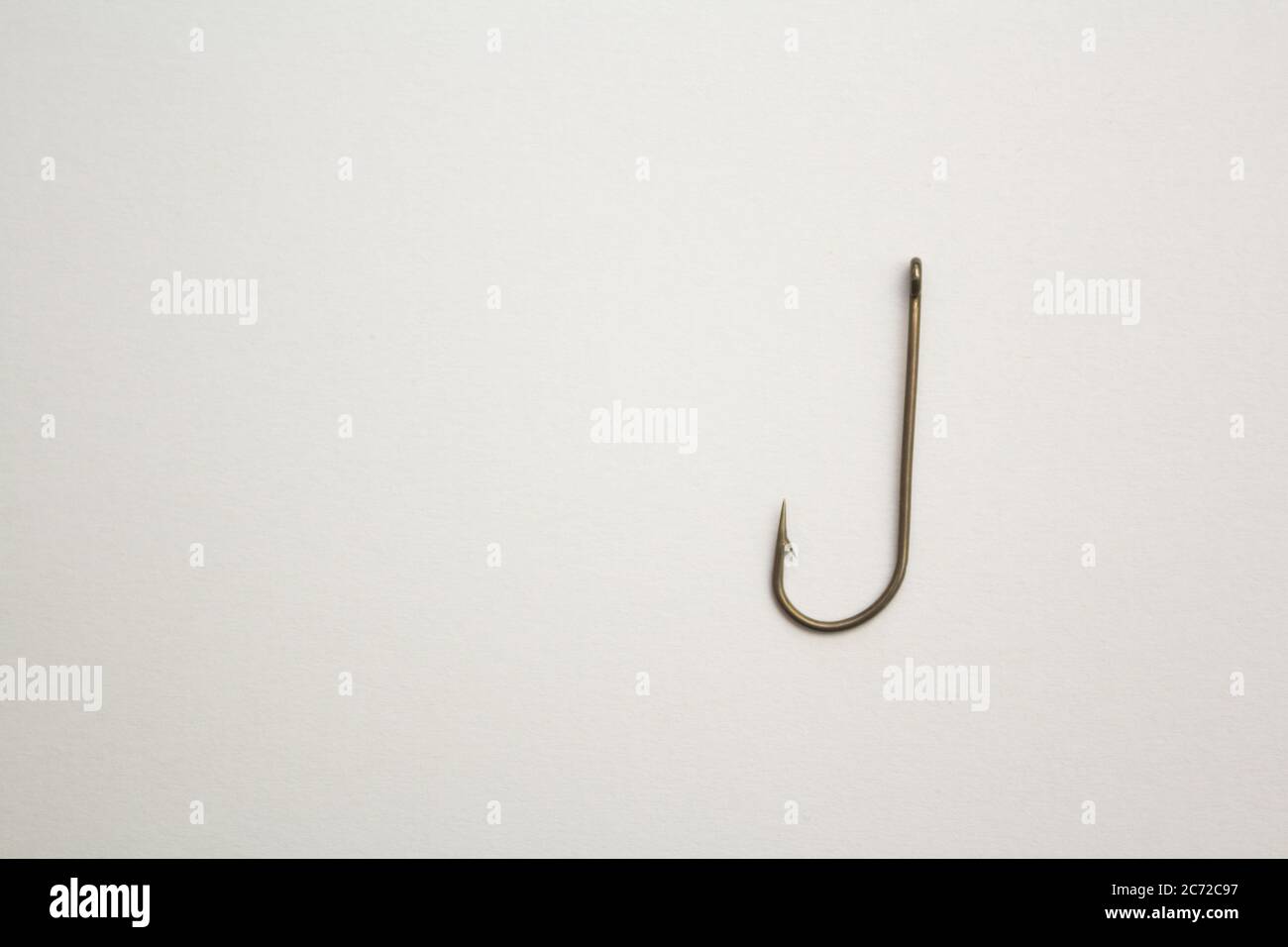 Fishing hook on a white paper background - closeup Stock Photo - Alamy