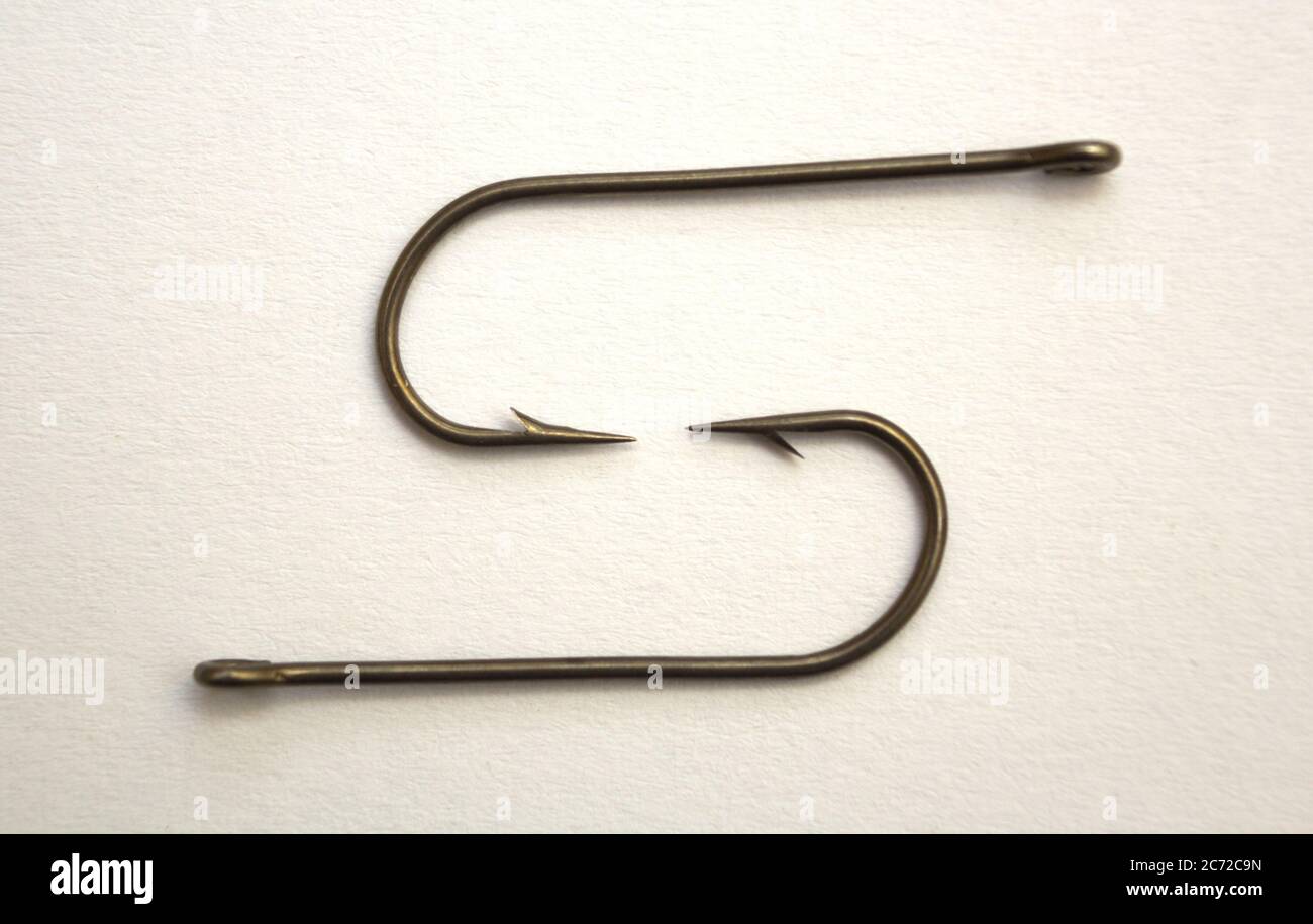 Two fishing hooks on a white paper background - closeup Stock Photo - Alamy