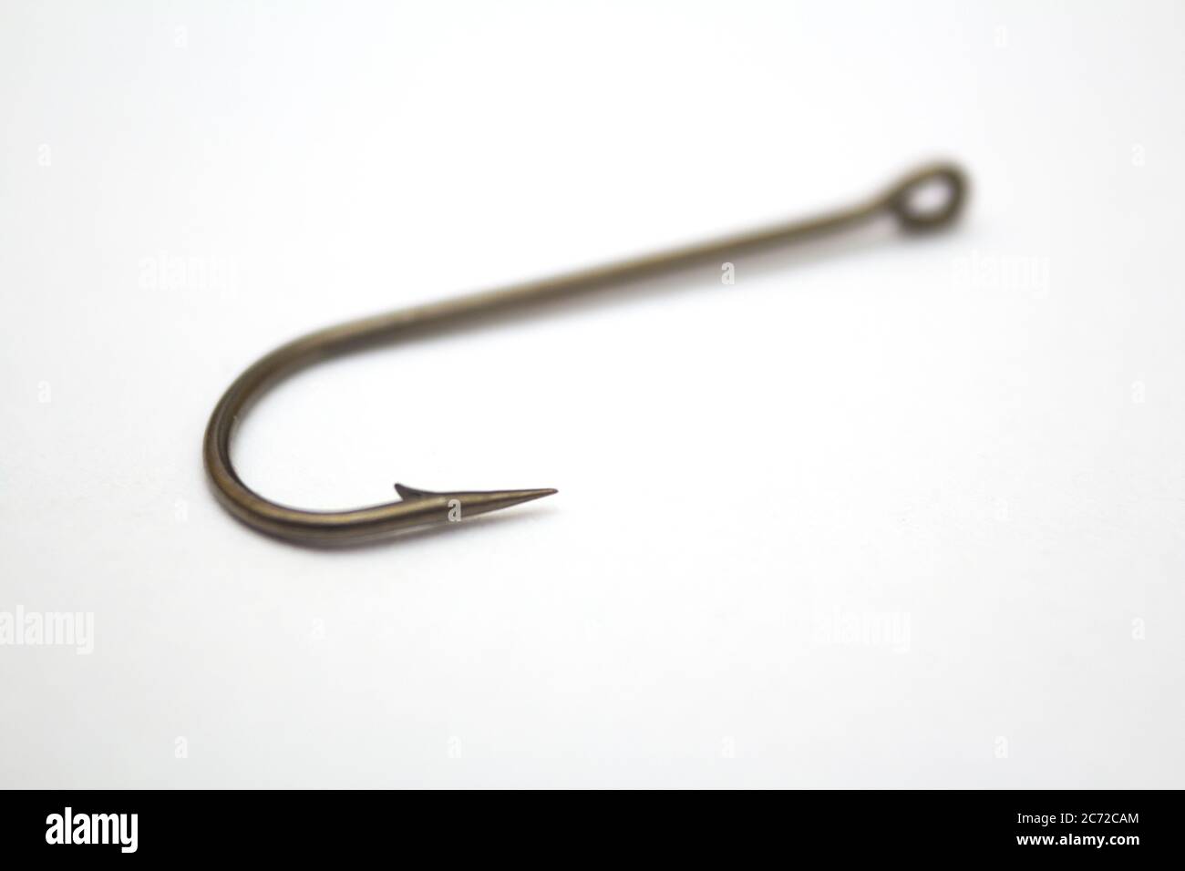 Fishing hook on a white paper background - closeup Stock Photo - Alamy