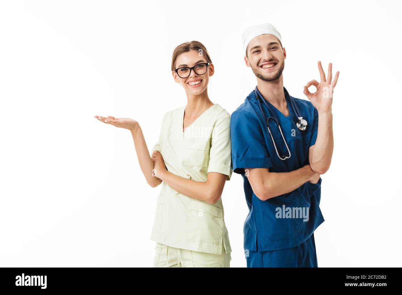 Young smiling doctor with phonendoscope on neck, happily showing ok ...