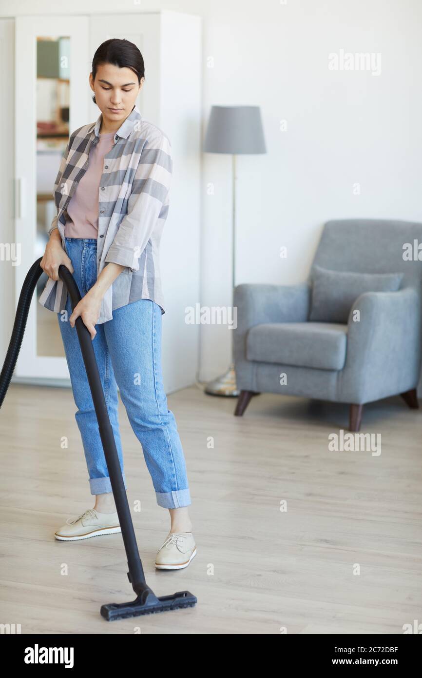 Young maid cleaning the house using vacuum cleaner Stock Photo - Alamy
