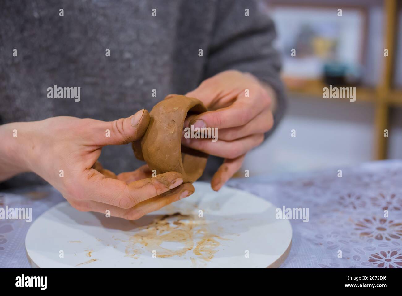 Professional male potter making clay tea cup in pottery workshop ...