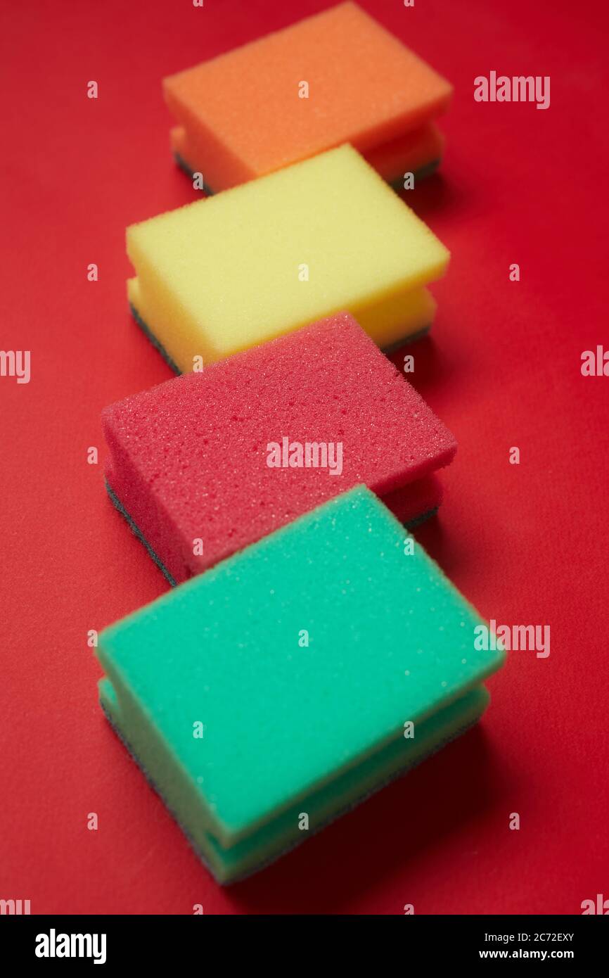Close-up of colorful sponges for cleaning lying in a row isolated on ...