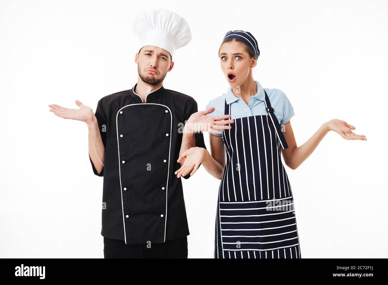 Young upset man chef in black uniform and white hat, and woman cook in ...