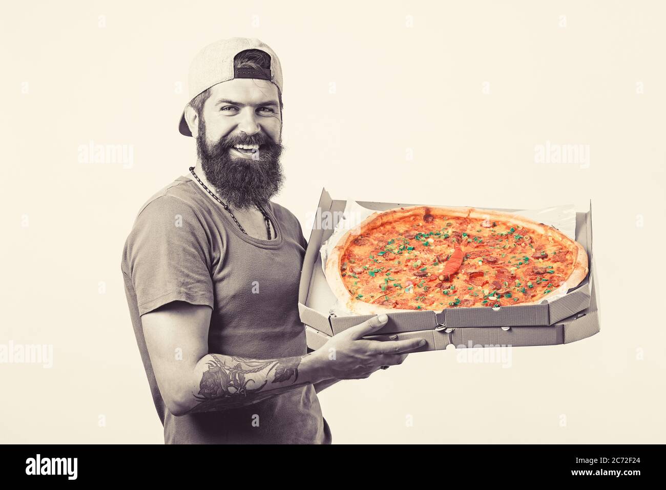 Smiling young delivery man holding pizza box Stock Photo - Alamy