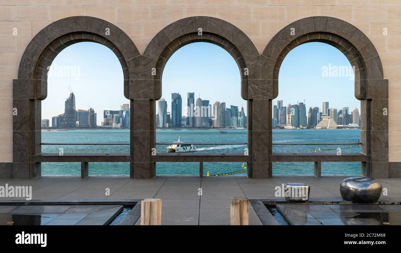 Doha, Qatar - February 2019: Doha skyline through the arches of the ... Doha, Qatar - February 2019: Doha skyline through the arches of the ...
