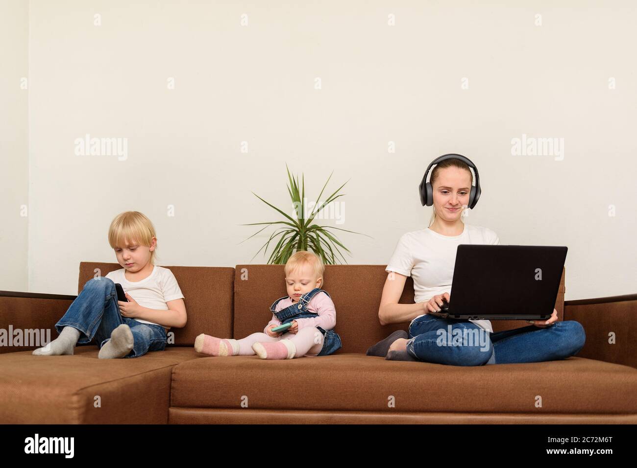Nanny with laptop to surf Internet while kids play with phones. Bad ...