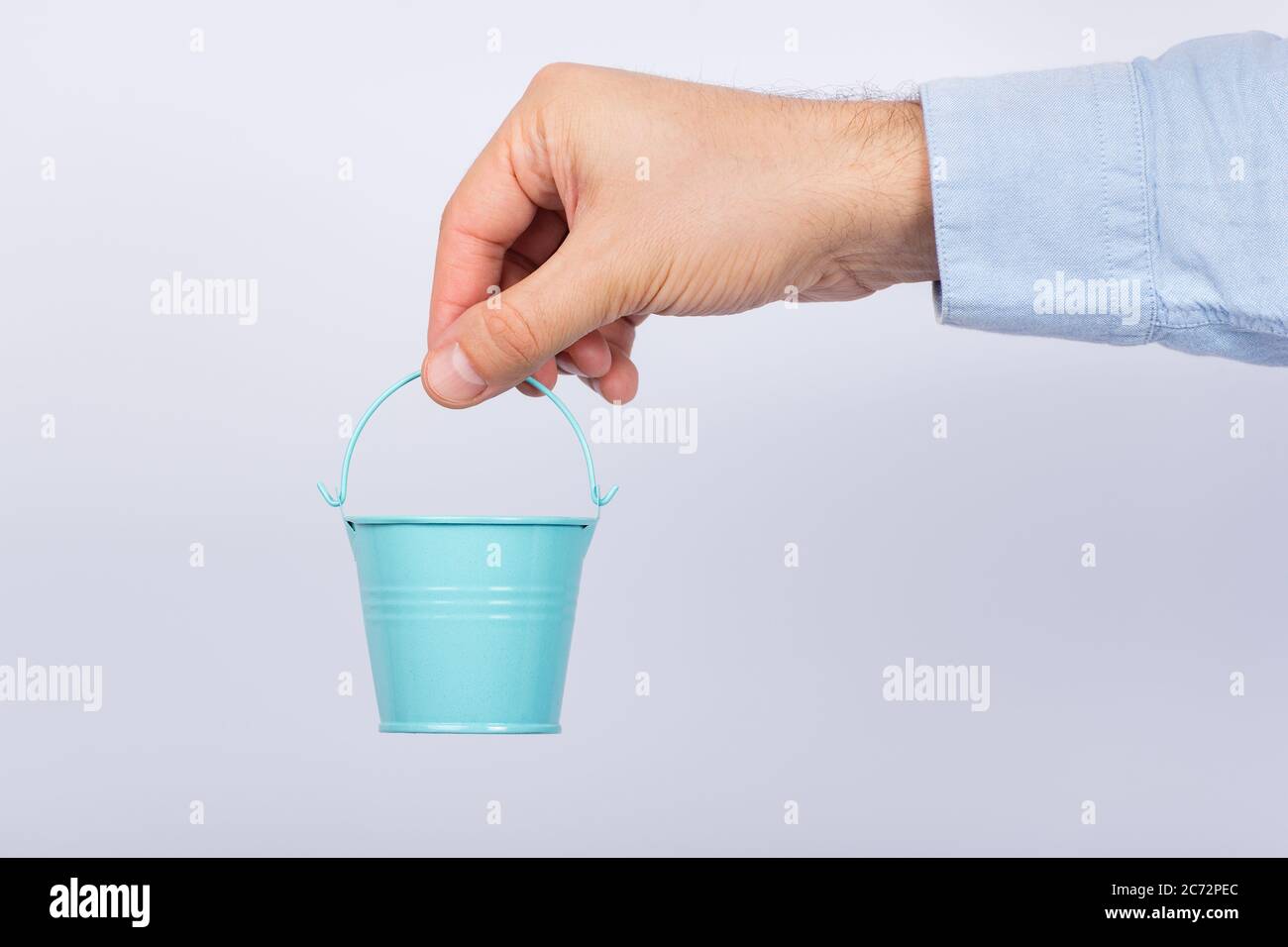 Male hand holds small buckets pails on white background Stock Photo - Alamy