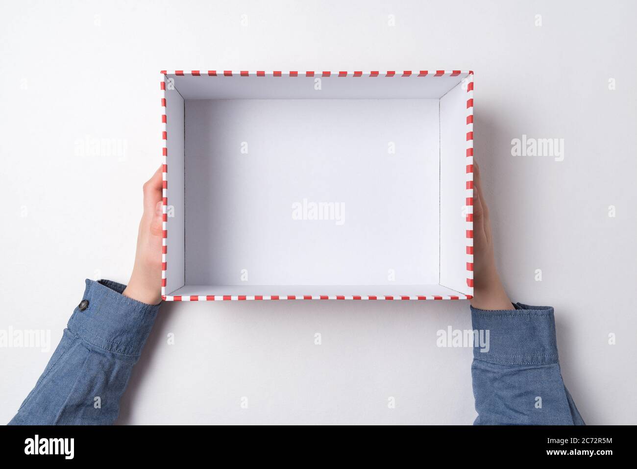 Open empty gift box in children's hands on white background. Top view ...