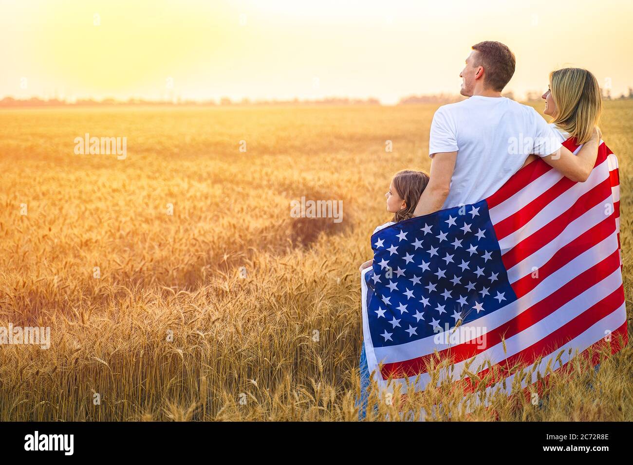 Back view of a unrecognizable Happy family in wheat field with USA ...
