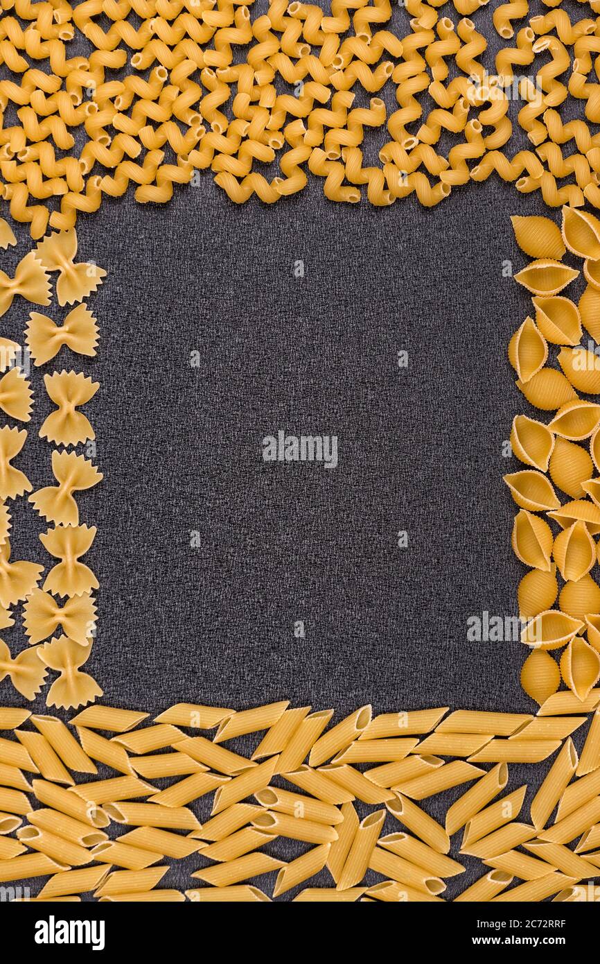 Different types of pasta on grey background. Cook background. Vertical ...