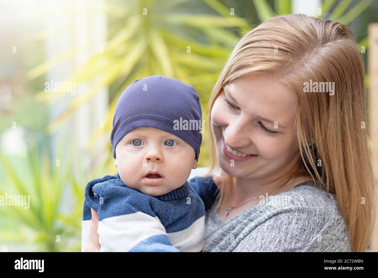 Portrait of toddler with a serious expression together with his smiling ...