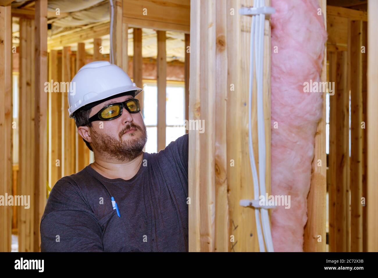Construction worker thermally insulating insulation layer under house ...