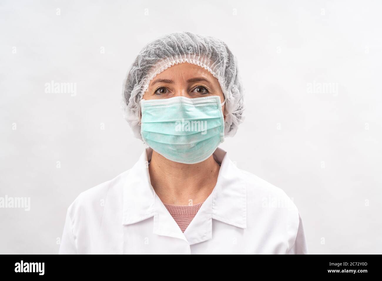 Tired female medic, nurse in protective equipment and a mask from ...