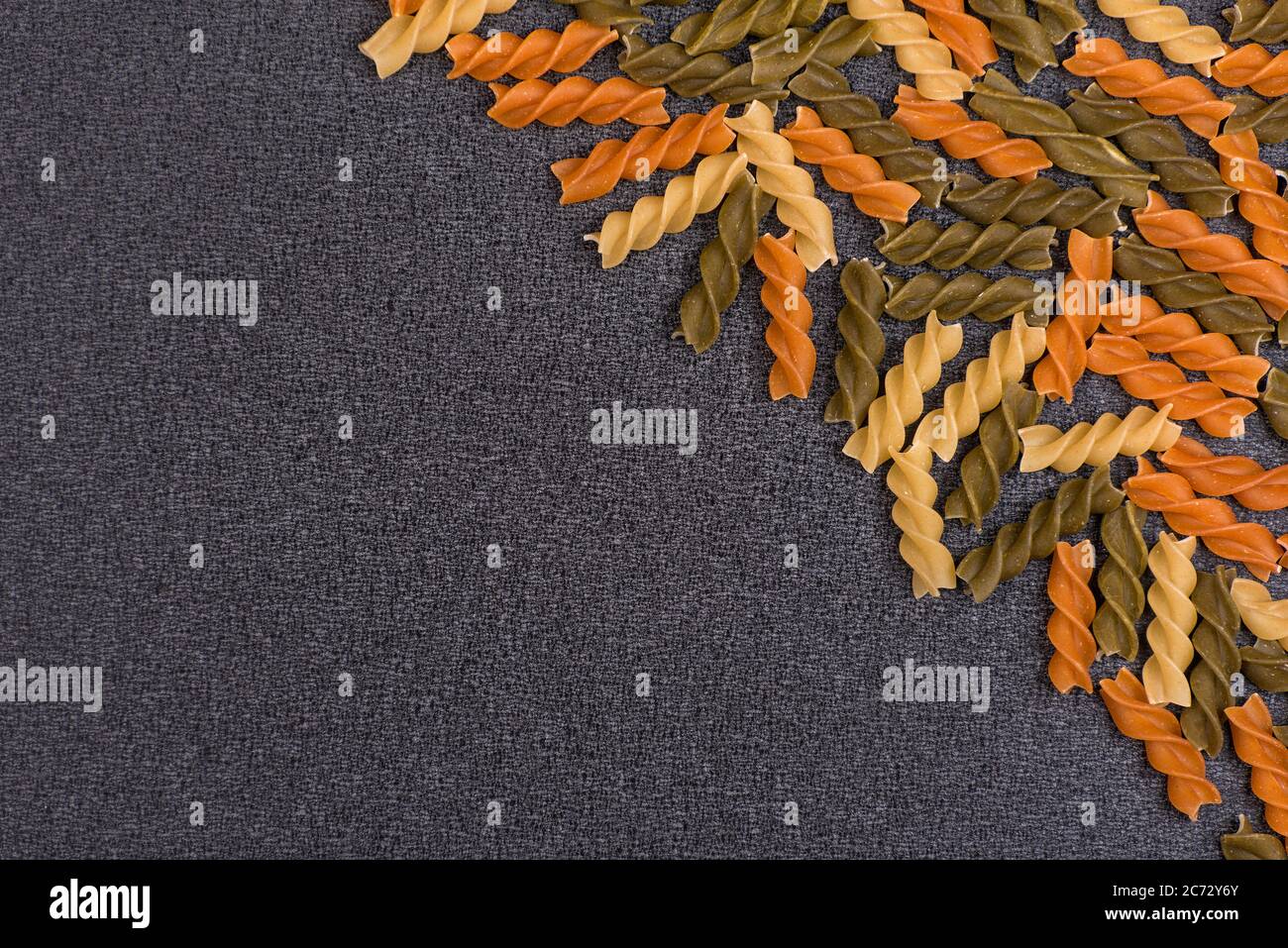 Fusilli on gray background. Multi-colored pasta. Culinary background ...