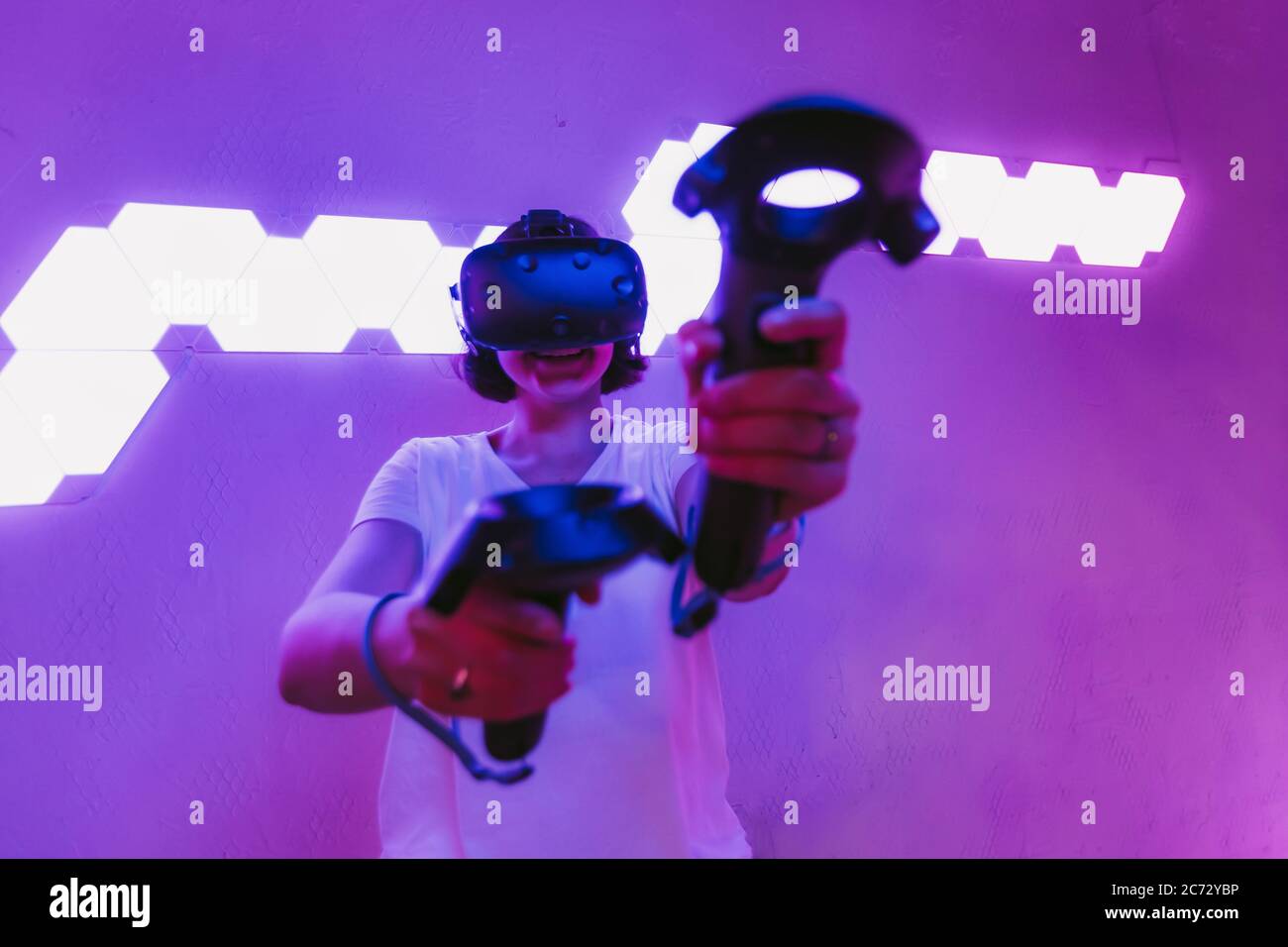Girl playing games in VR glasses. Neon purple room. Cyberpunk games ...