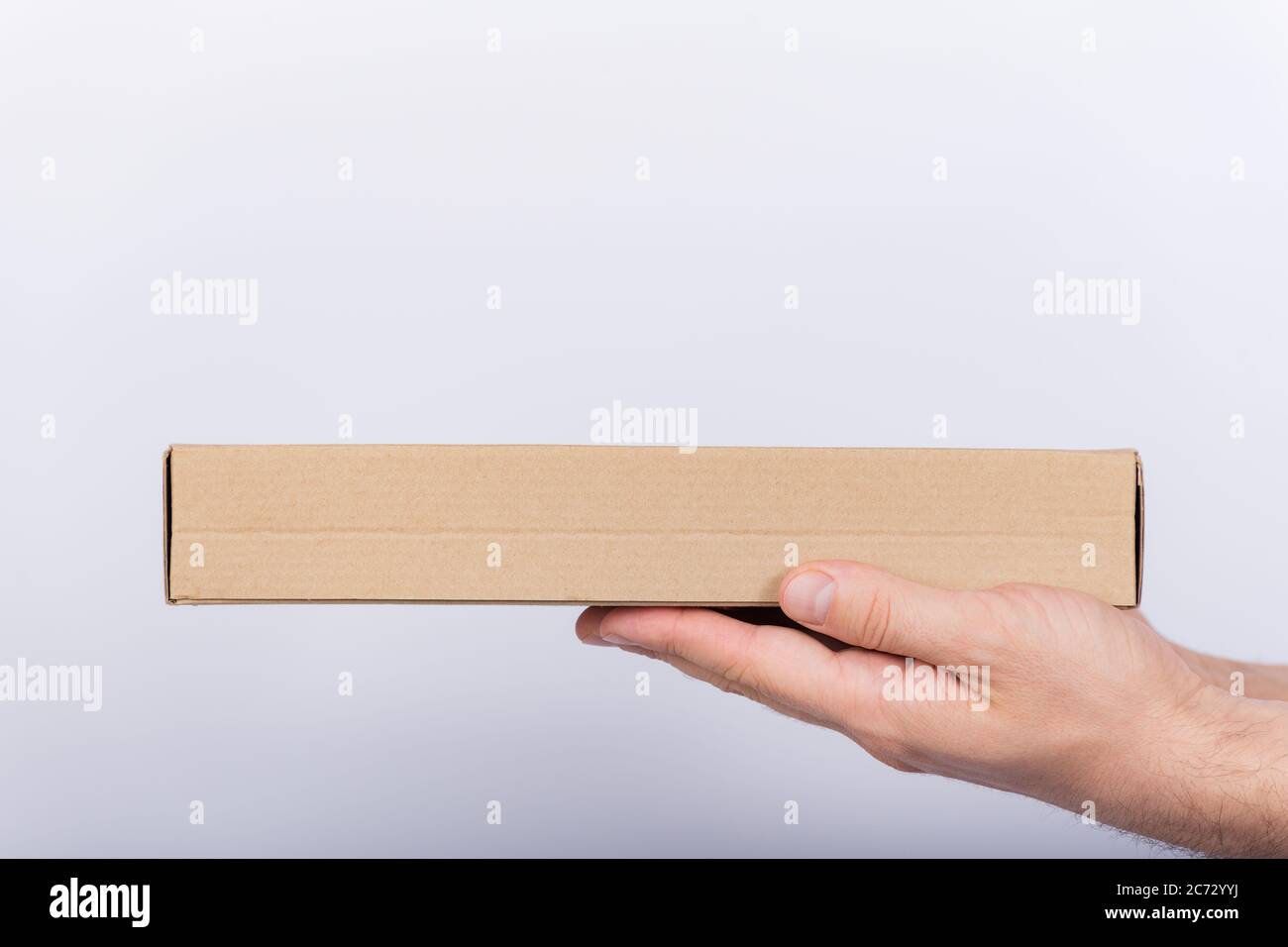 Flat cardboard box in male hands. Delivery of parcels. Side view Stock ...