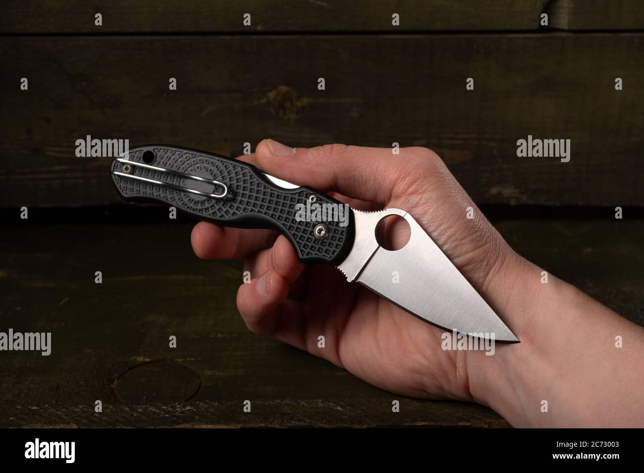 Pocket knife in the hand. Knife with plastic handle and clip. Hold the ...