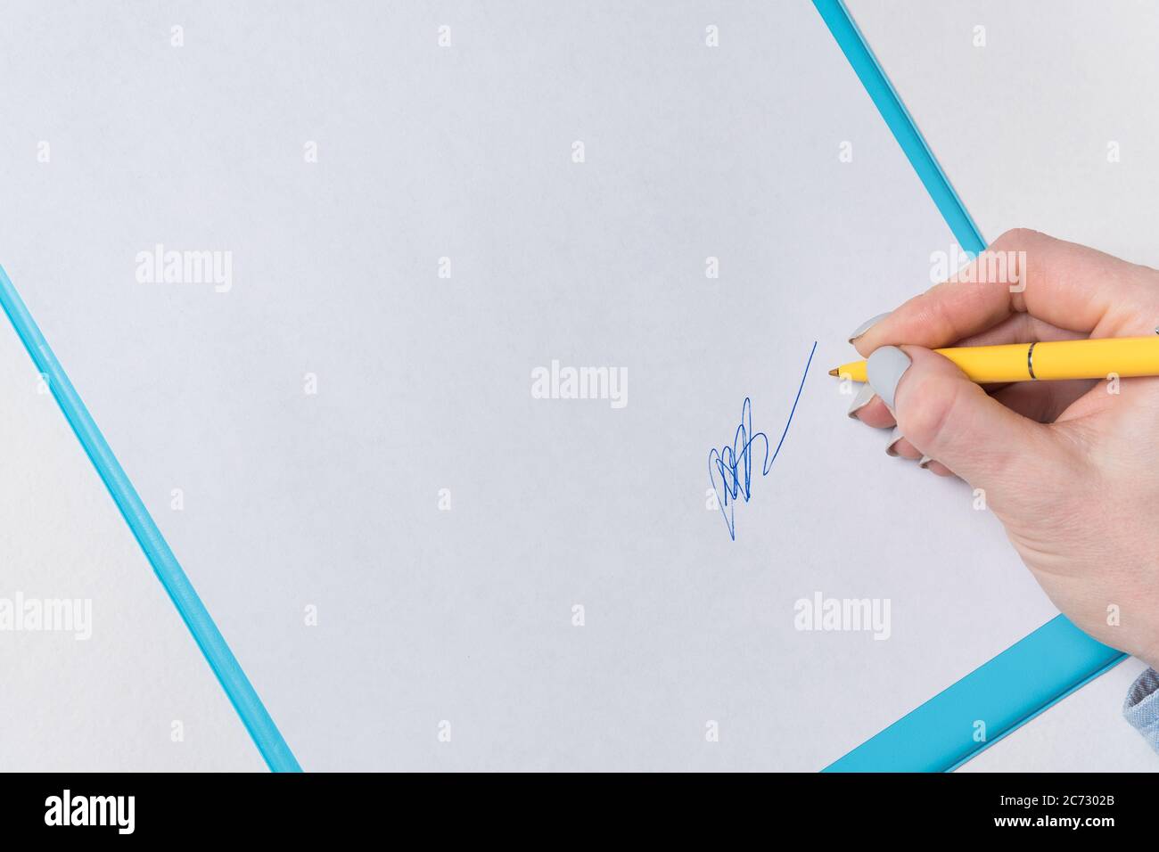 Woman's hand puts his signature on sheet of paper. Sign in document ...
