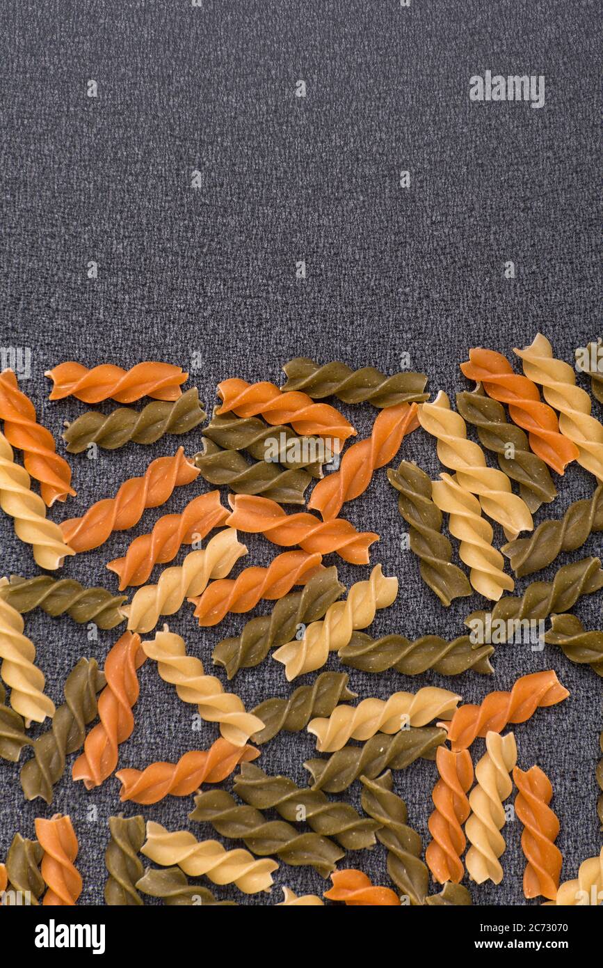 multi-colored Fusilli on gray background. Pasta background. Vertical ...